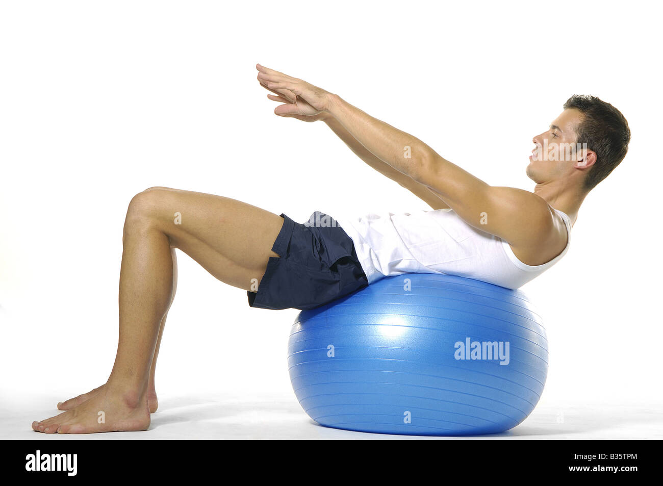 Side profile of a young man exercising with a fitness ball Stock Photo ...
