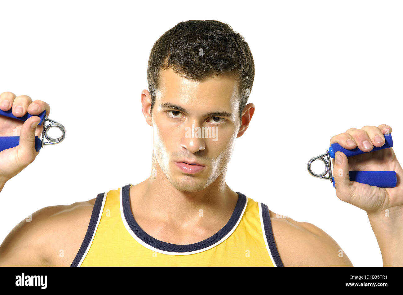 Portrait of a young man squeezing handgrips Stock Photo - Alamy