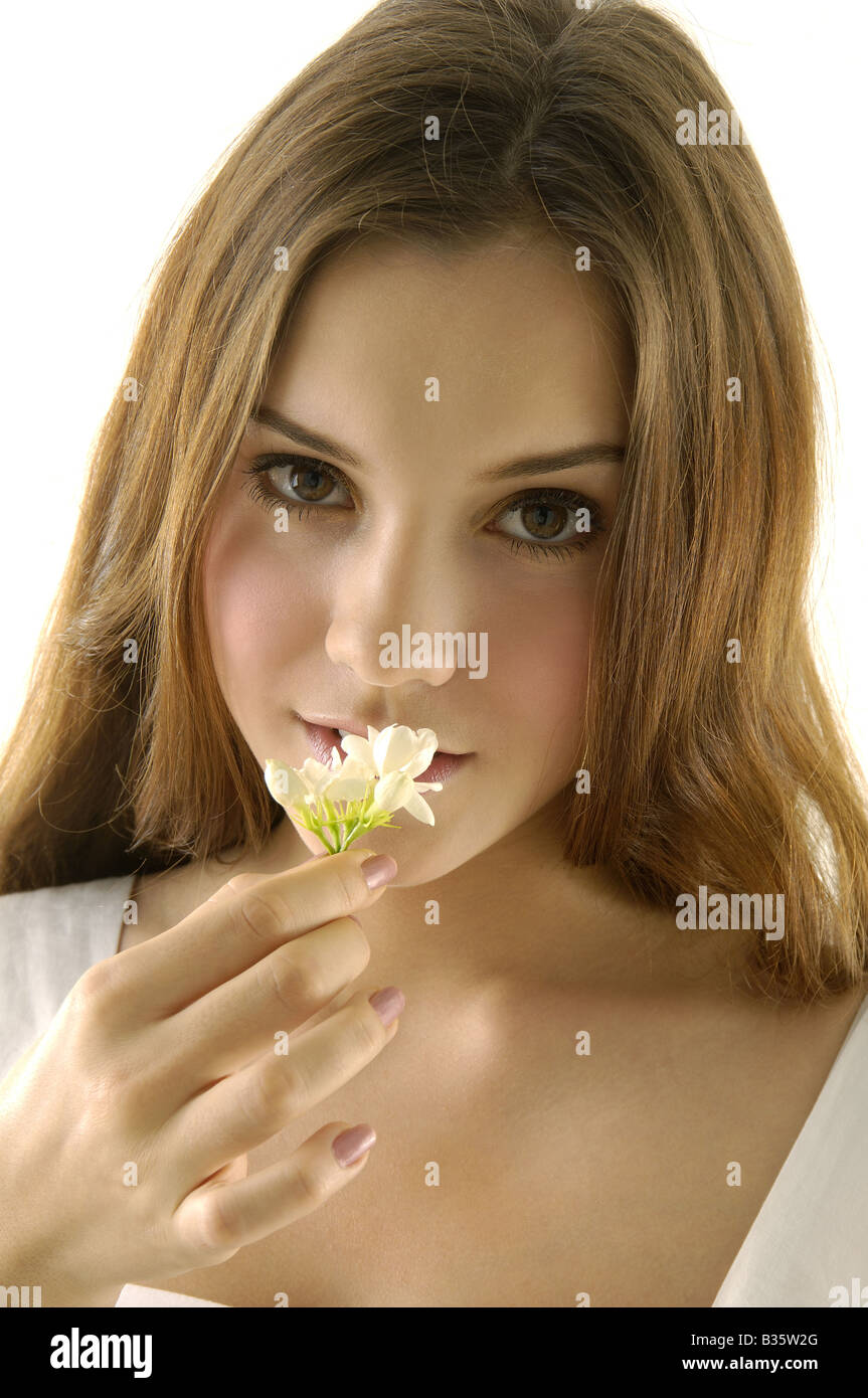 Portrait of a young woman smelling a flower Stock Photo - Alamy