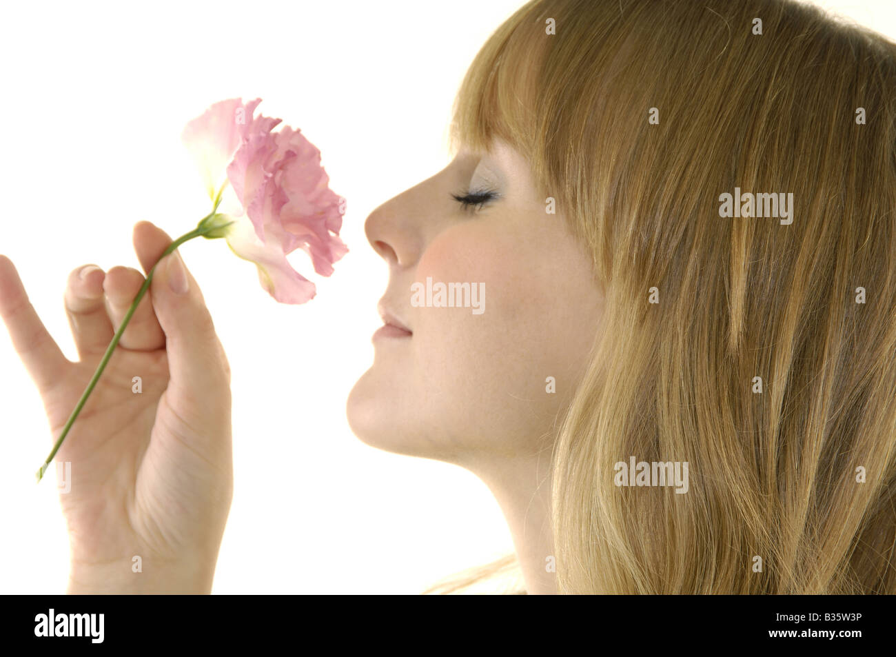 Close-up of a young woman smelling a flower Stock Photo - Alamy
