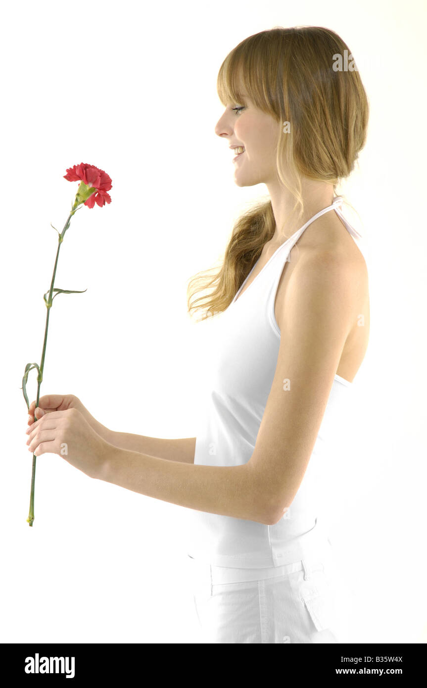 Side profile of a young woman holding a flower Stock Photo - Alamy