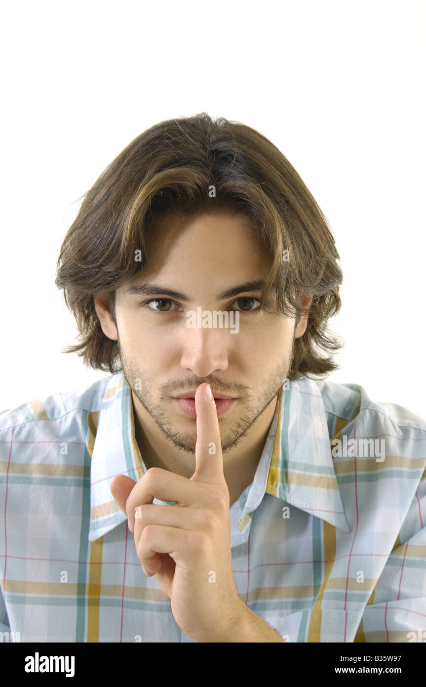 Portrait of a young man with his finger on his lips Stock Photo - Alamy