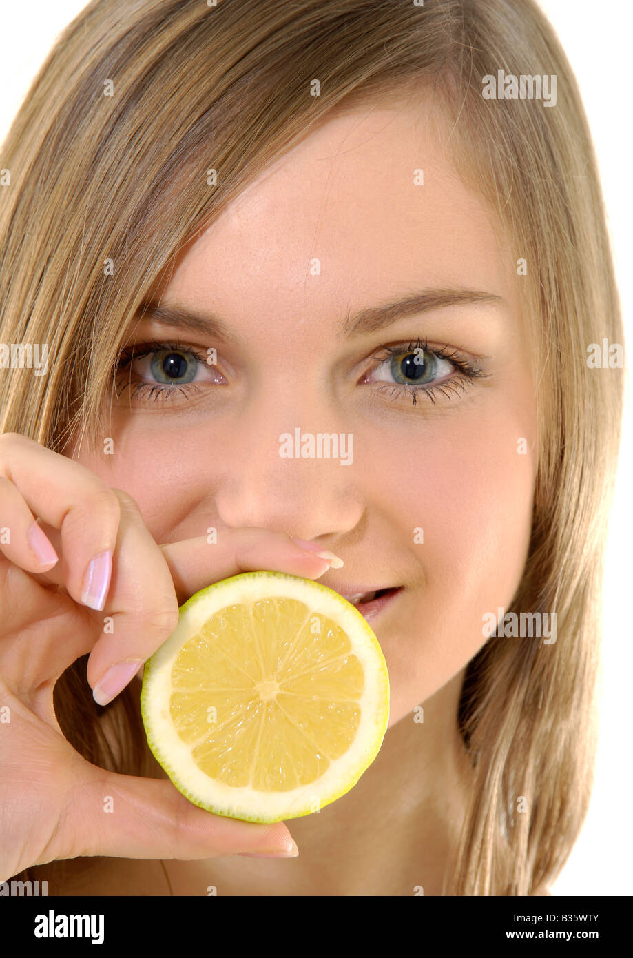 Portrait of a young woman holding a cross section of a lime Stock Photo ...