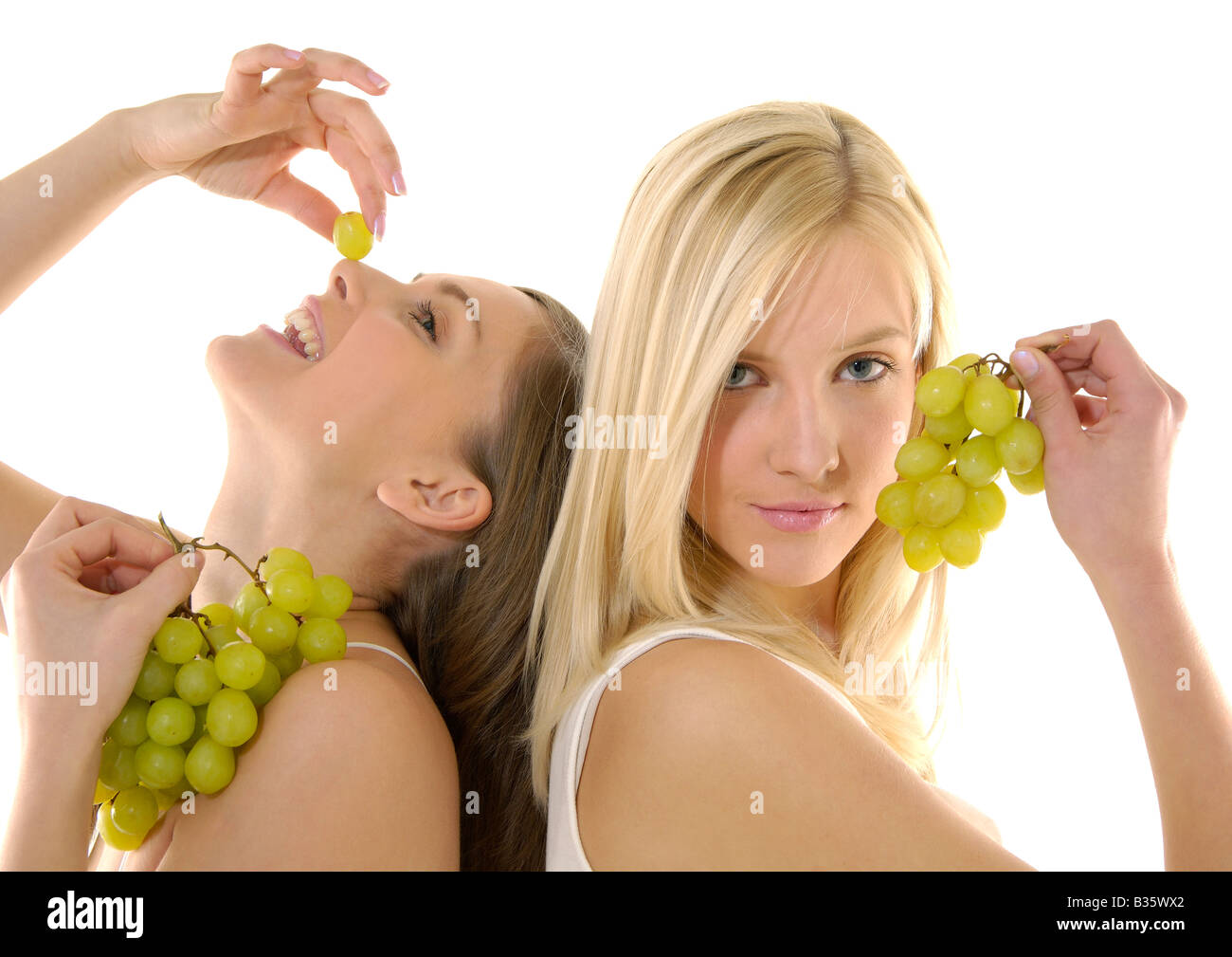 Close-up of two young women holding bunches of grapes Stock Photo - Alamy