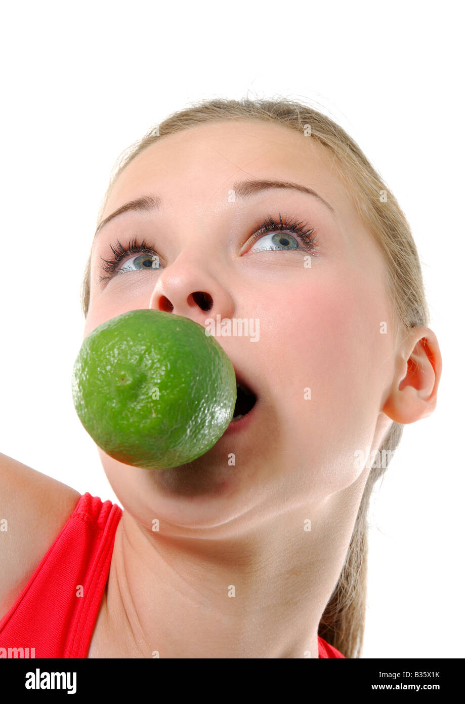Close-up of a young woman biting a lime on her mouth Stock Photo - Alamy