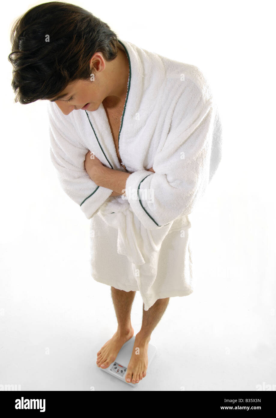 High angle view of a young man weighing himself on a scale Stock Photo ...