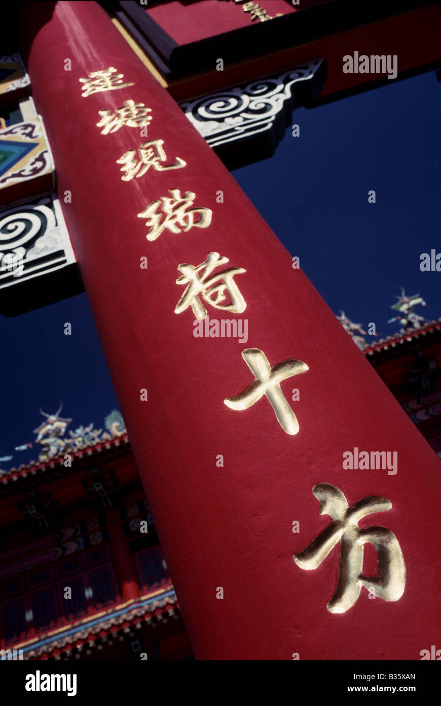 Detail looking up of a red pillar with gold Chinese symbols at a ...