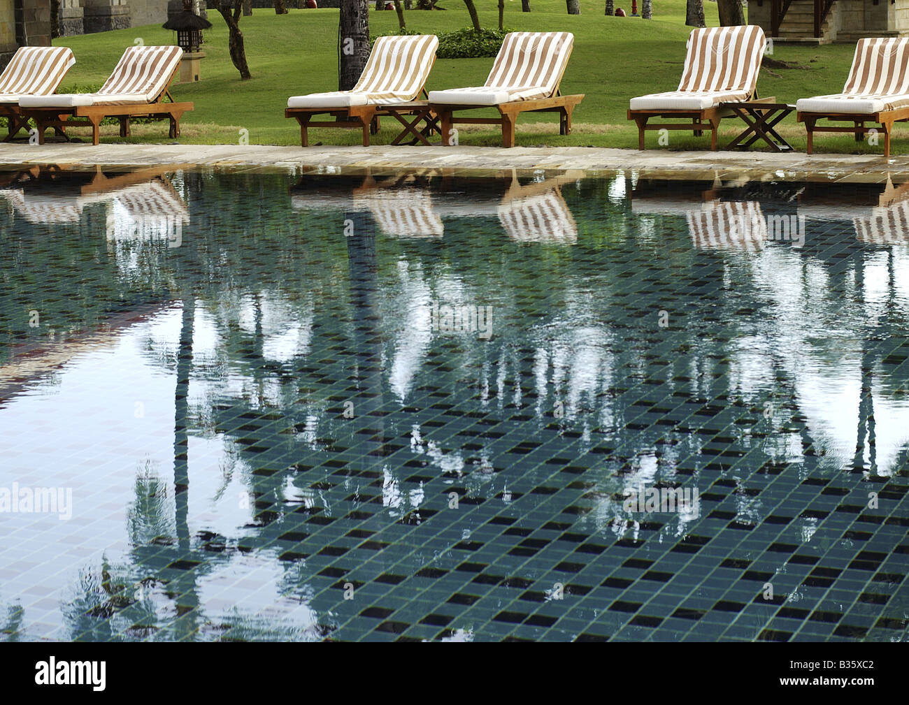 View of deck chairs by a swimming pool Stock Photo - Alamy