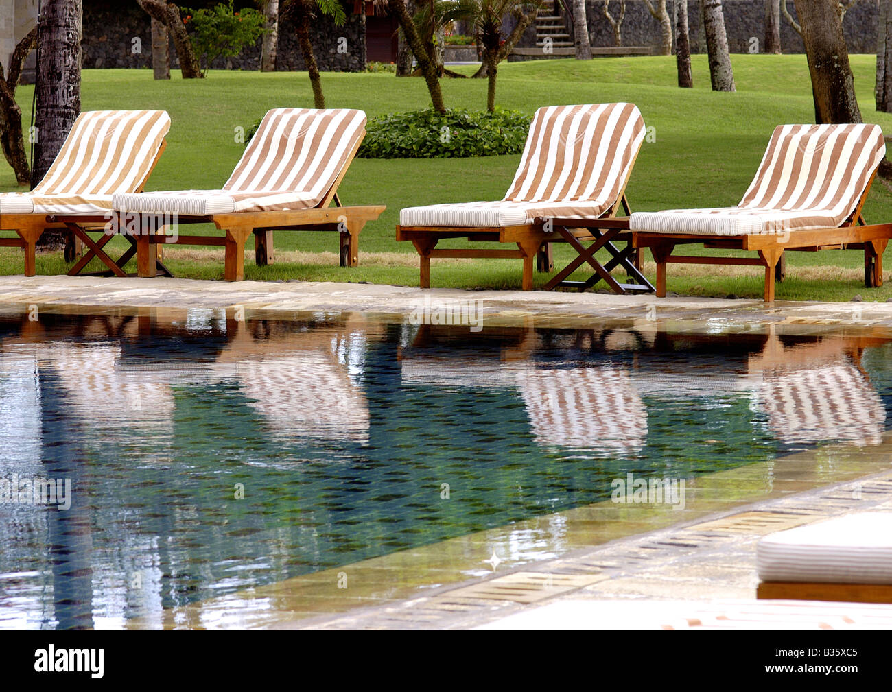View of deck chairs by a swimming pool Stock Photo - Alamy