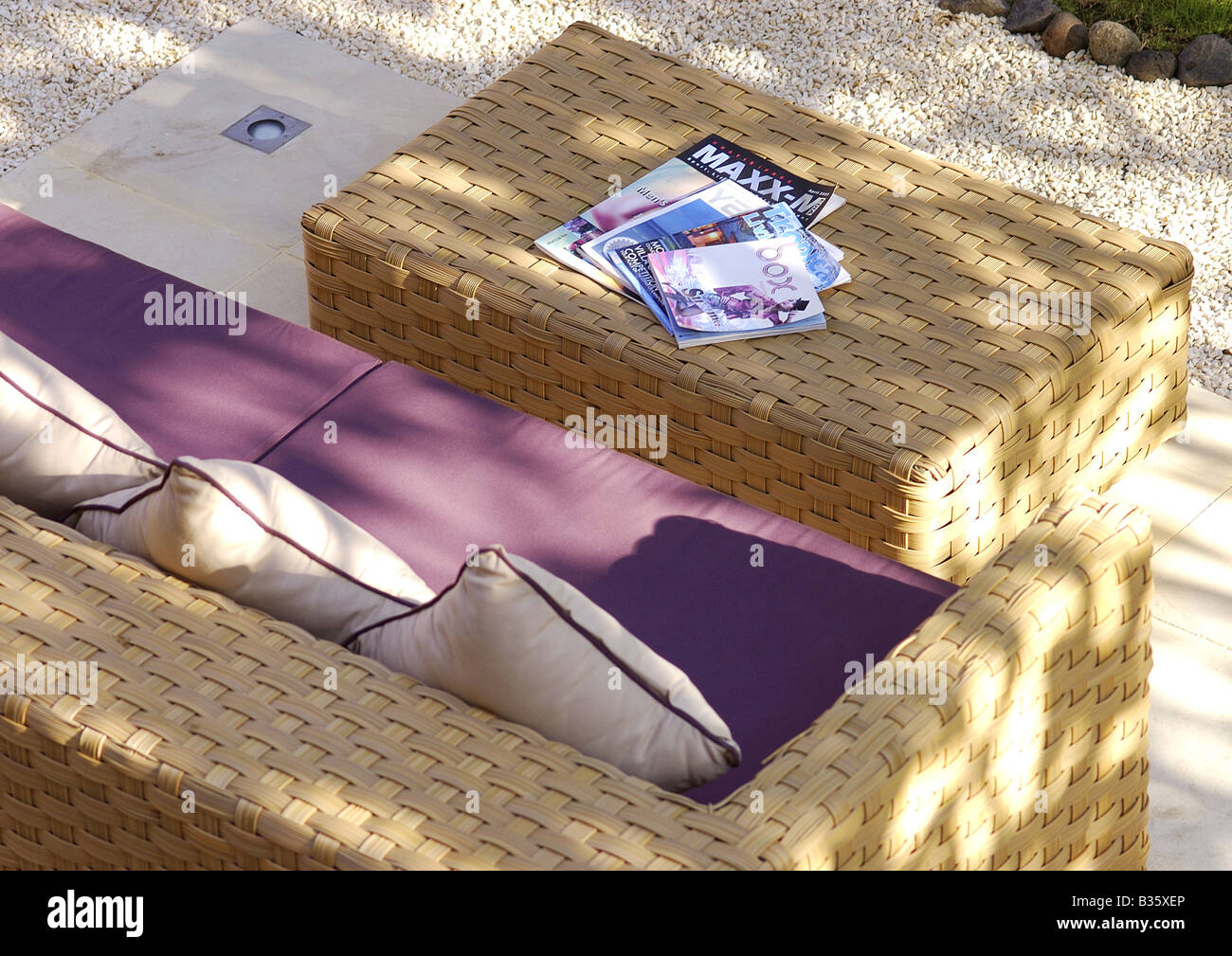 View of a comfortable cane couch and a table Stock Photo - Alamy