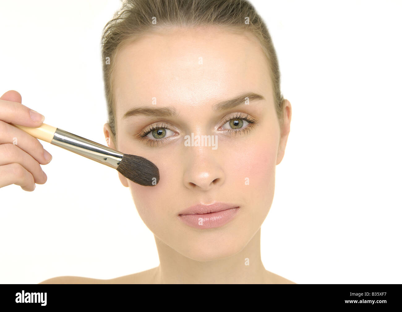 Portrait of a young woman applying blush Stock Photo - Alamy