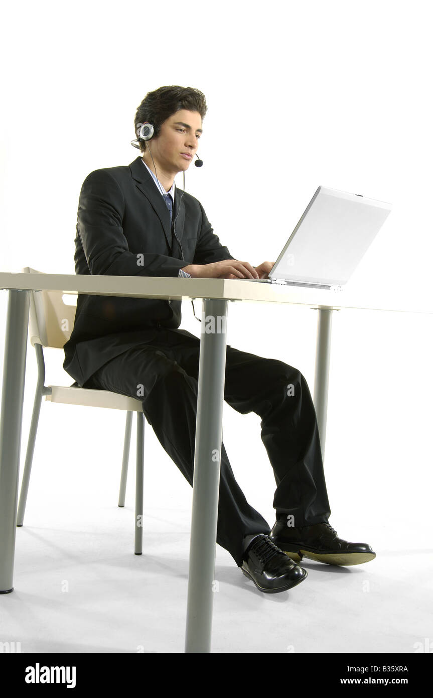Male customer service representative sitting at a table and using a ...