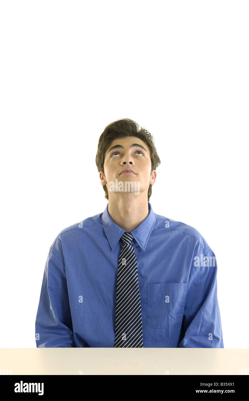 Businessman sitting at a desk and looking up in an office Stock Photo ...