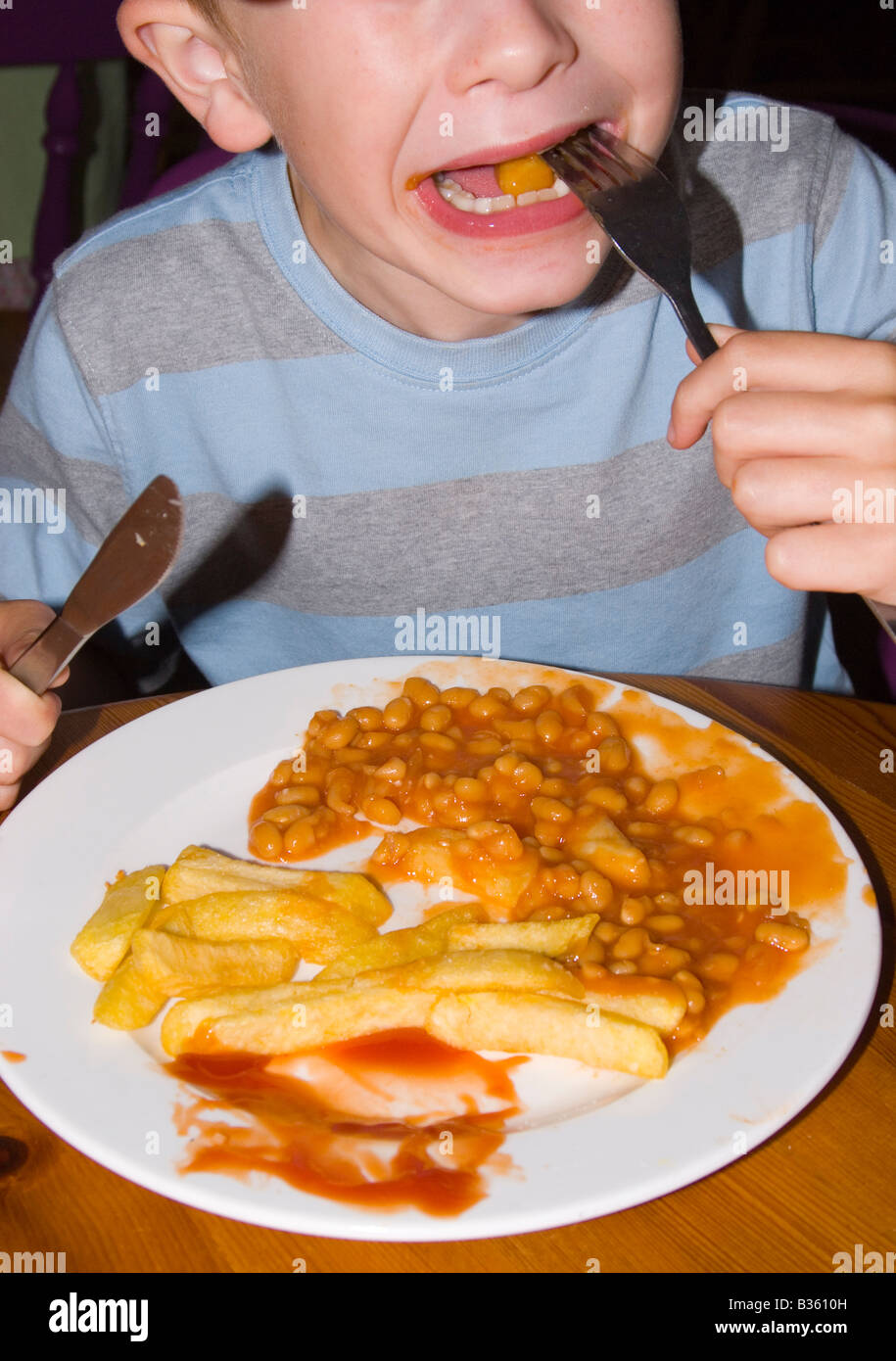 Young boy eating chips and beans Stock Photo - Alamy
