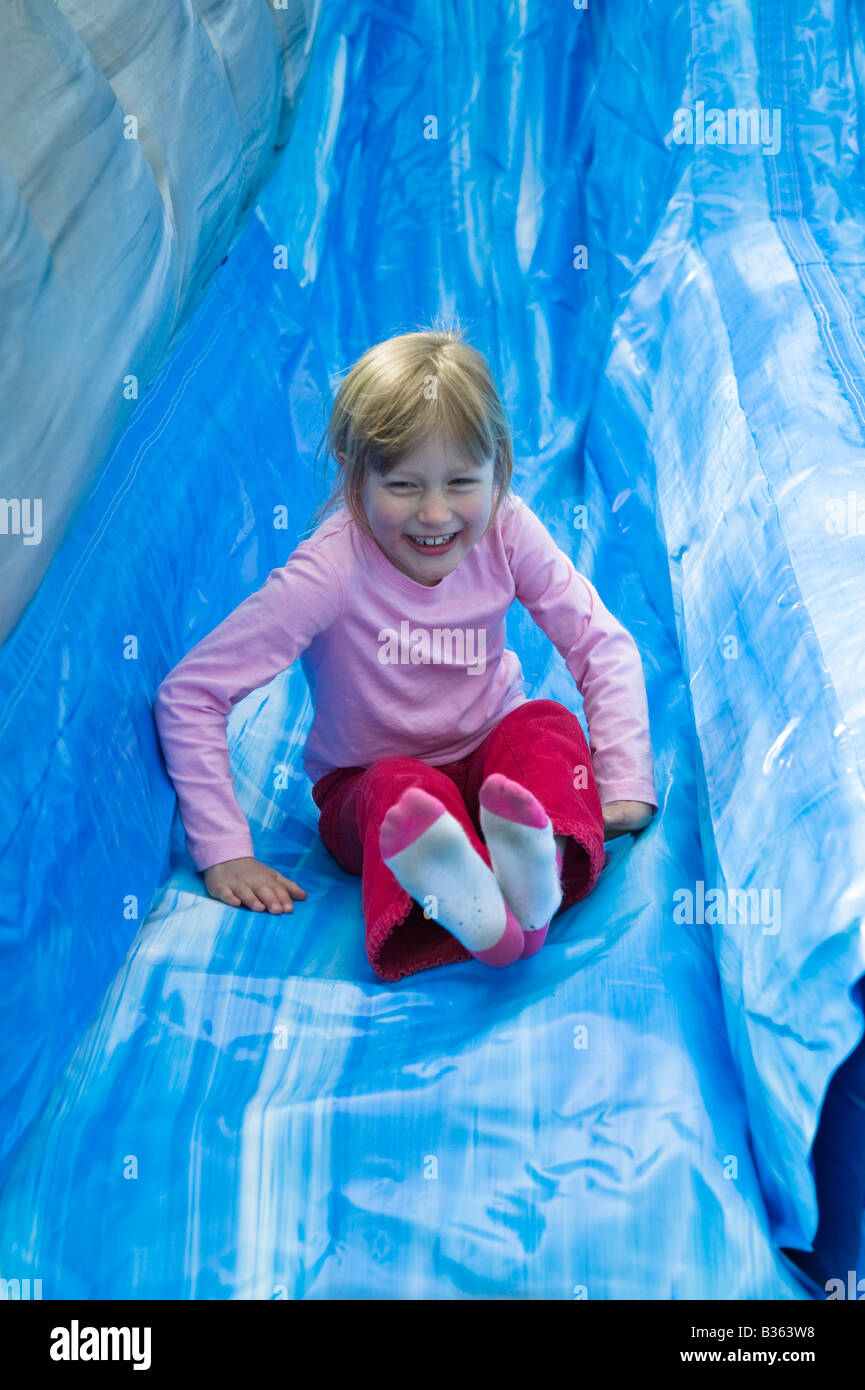 Girl sliding down a big slide Stock Photo - Alamy