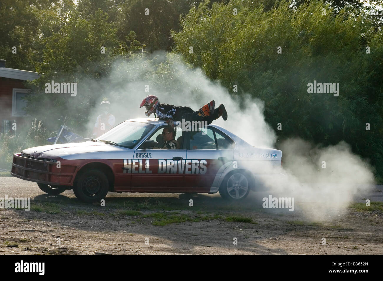 Stunt car driver on the roof of a BMW car making turns Stock Photo - Alamy