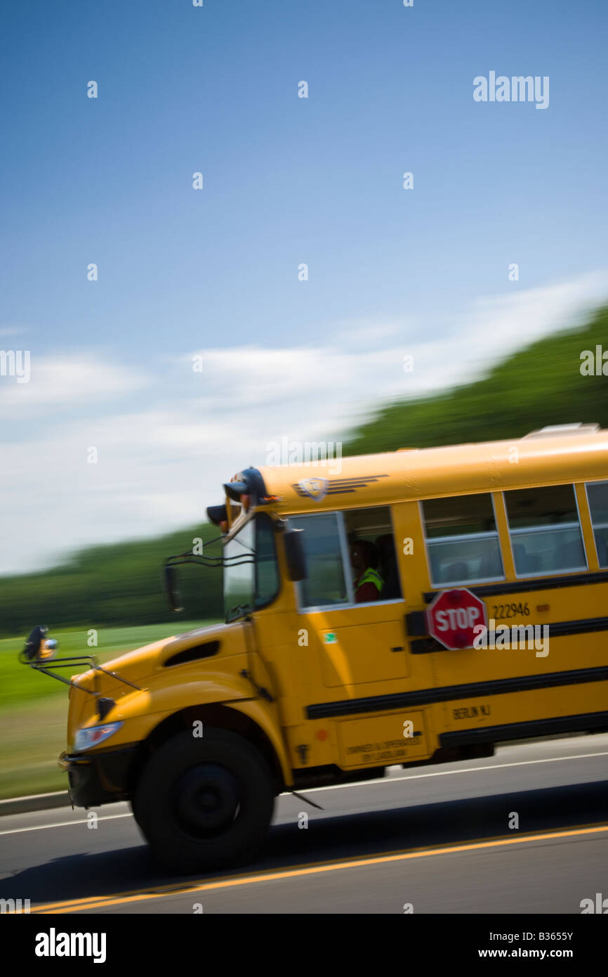 School bus driving down the road with motion blur Stock Photo - Alamy