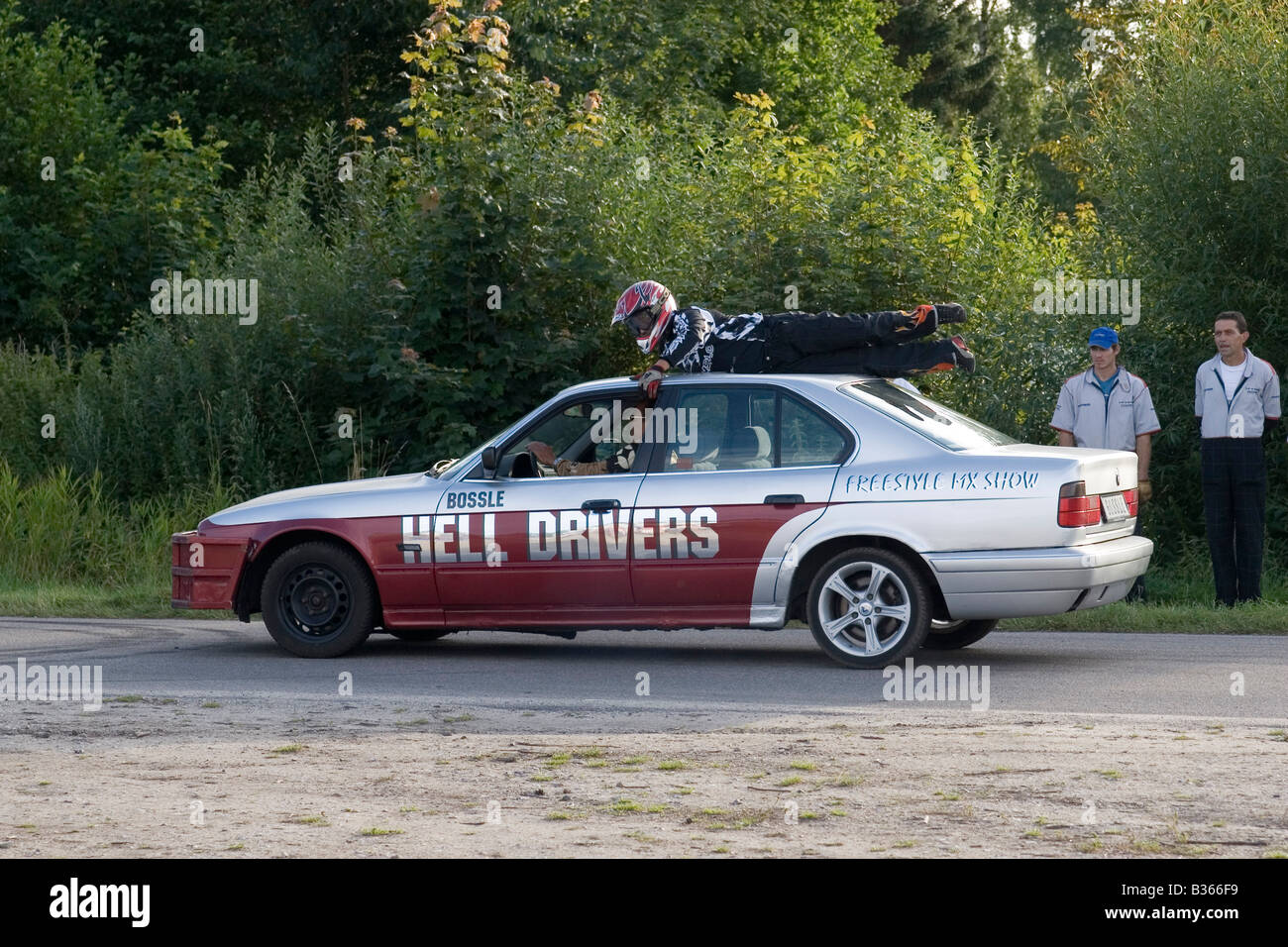 Stunt car driver on the roof of a BMW car making turns Stock Photo - Alamy