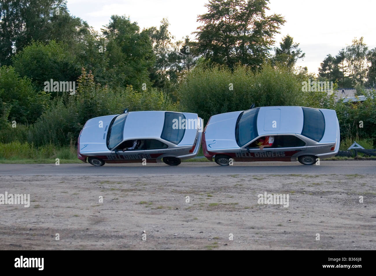 Two BMW cars on 2 wheels stunt Stock Photo - Alamy