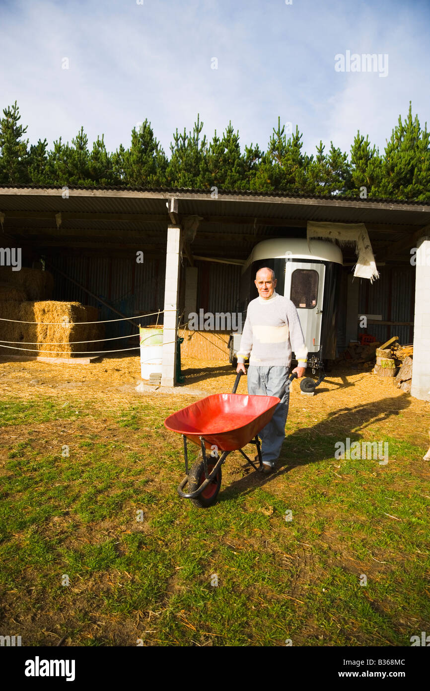 Senior man pushing wheelbarrow Stock Photo - Alamy