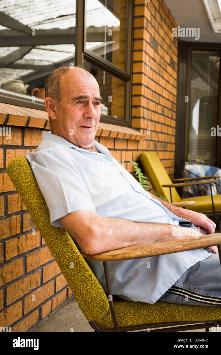 Senior man sitting on chair Stock Photo - Alamy