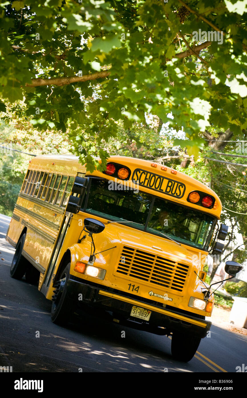 School bus driving down the road Stock Photo - Alamy