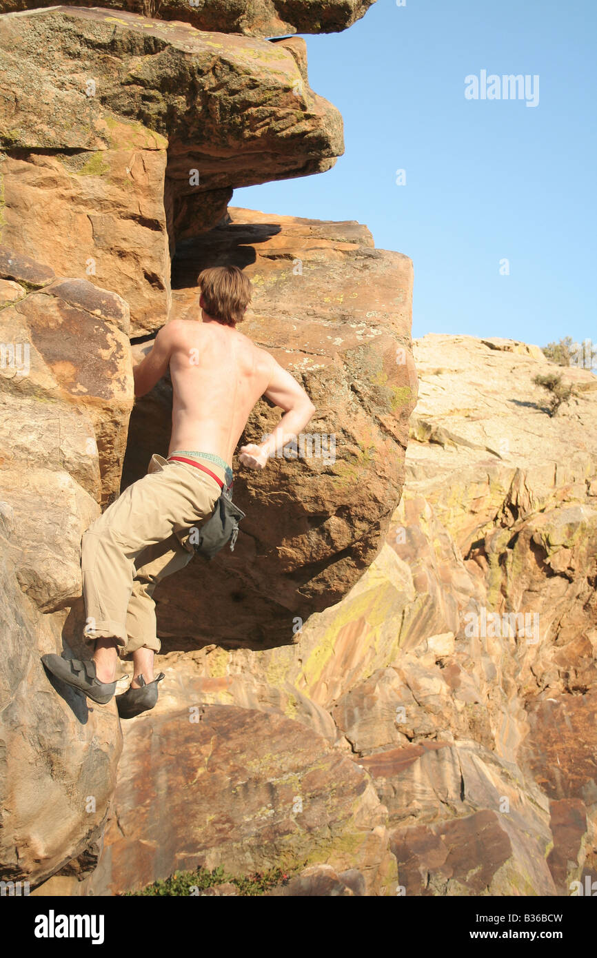 Rock climber scaling a wall with no ropes Stock Photo - Alamy