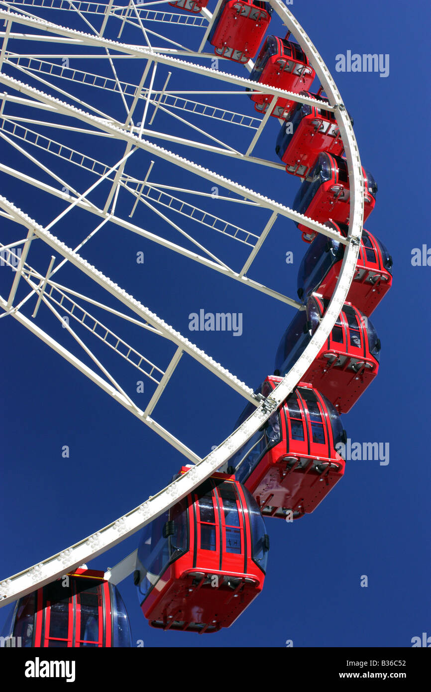 WHITE FERRIS WHEEL WITH RED CARRIAGES AGAINST BLUE SKY BACKGROUND ...