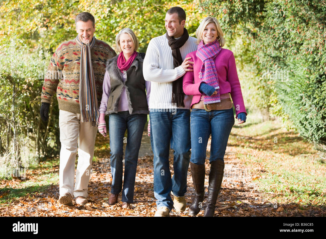 Two couples walking outdoors in park smiling Stock Photo - Alamy