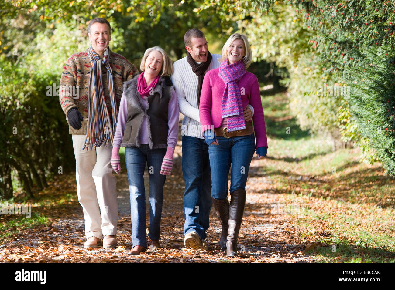 Two couples walking outdoors in park and smiling Stock Photo - Alamy