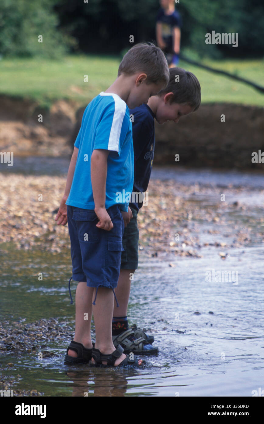 boys paddling fully dressed in stream Stock Photo - Alamy