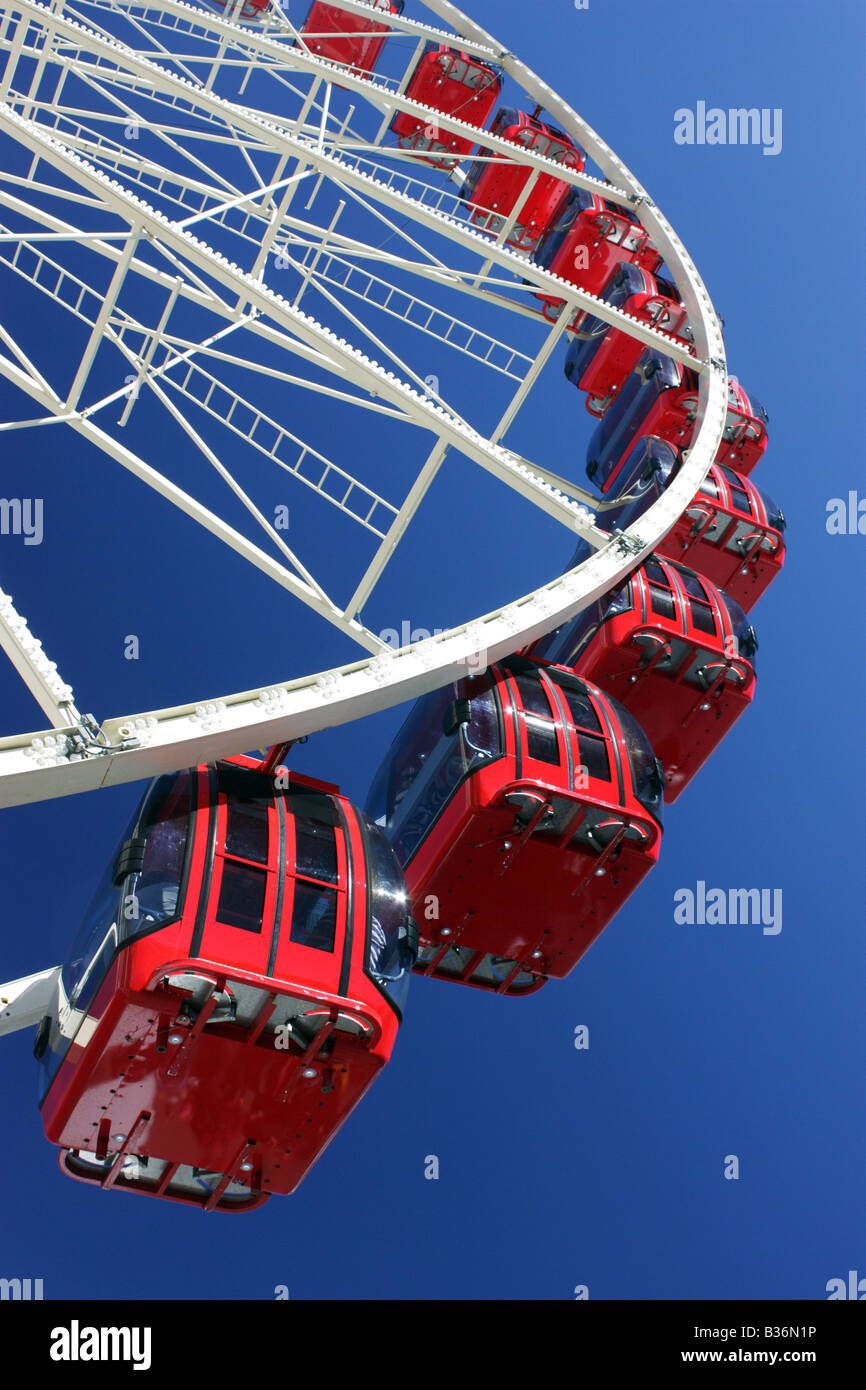 WHITE FERRIS WHEEL WITH RED CARRIAGES AGAINST BLUE SKY BACKGROUND ...