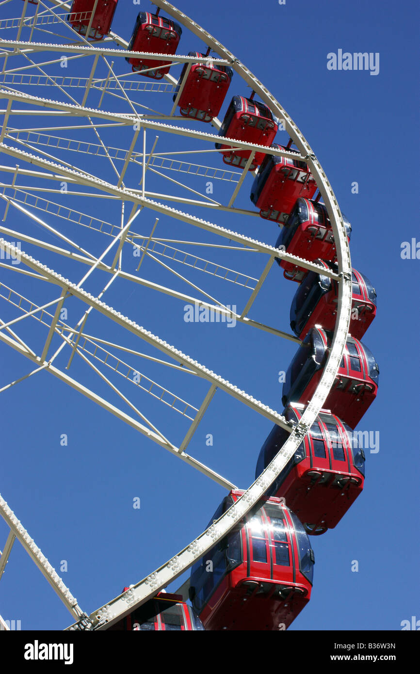 WHITE FERRIS WHEEL WITH RED CARRIAGES AGAINST BLUE SKY BACKGROUND ...