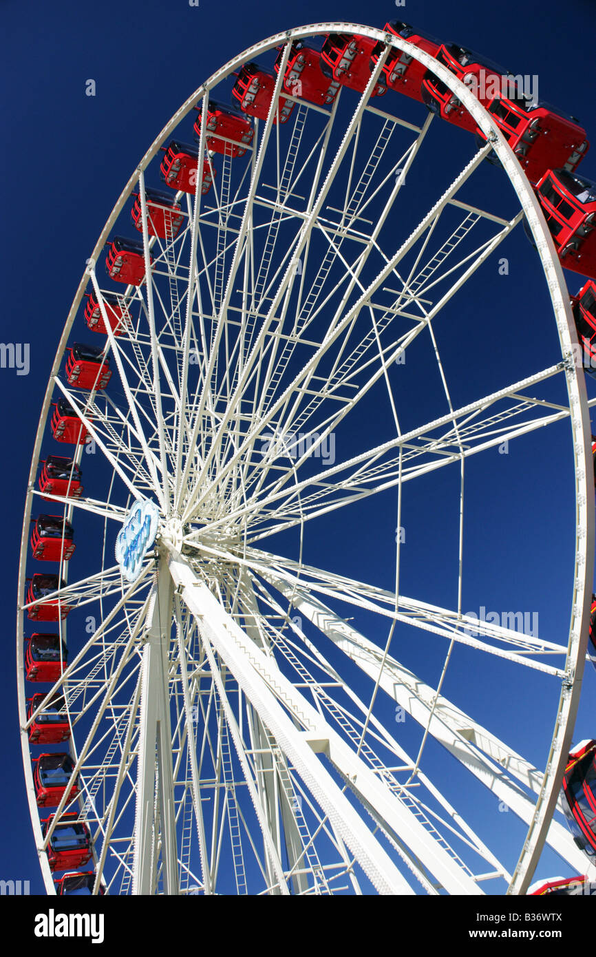 WHITE FERRIS WHEEL WITH RED CARRIAGES AGAINST BLUE SKY BACKGROUND ...