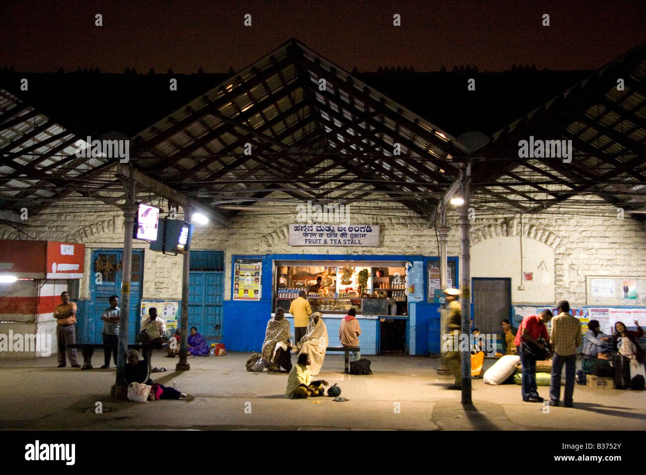 People Wait For A Train At Night Within Bangalore Railway Station The