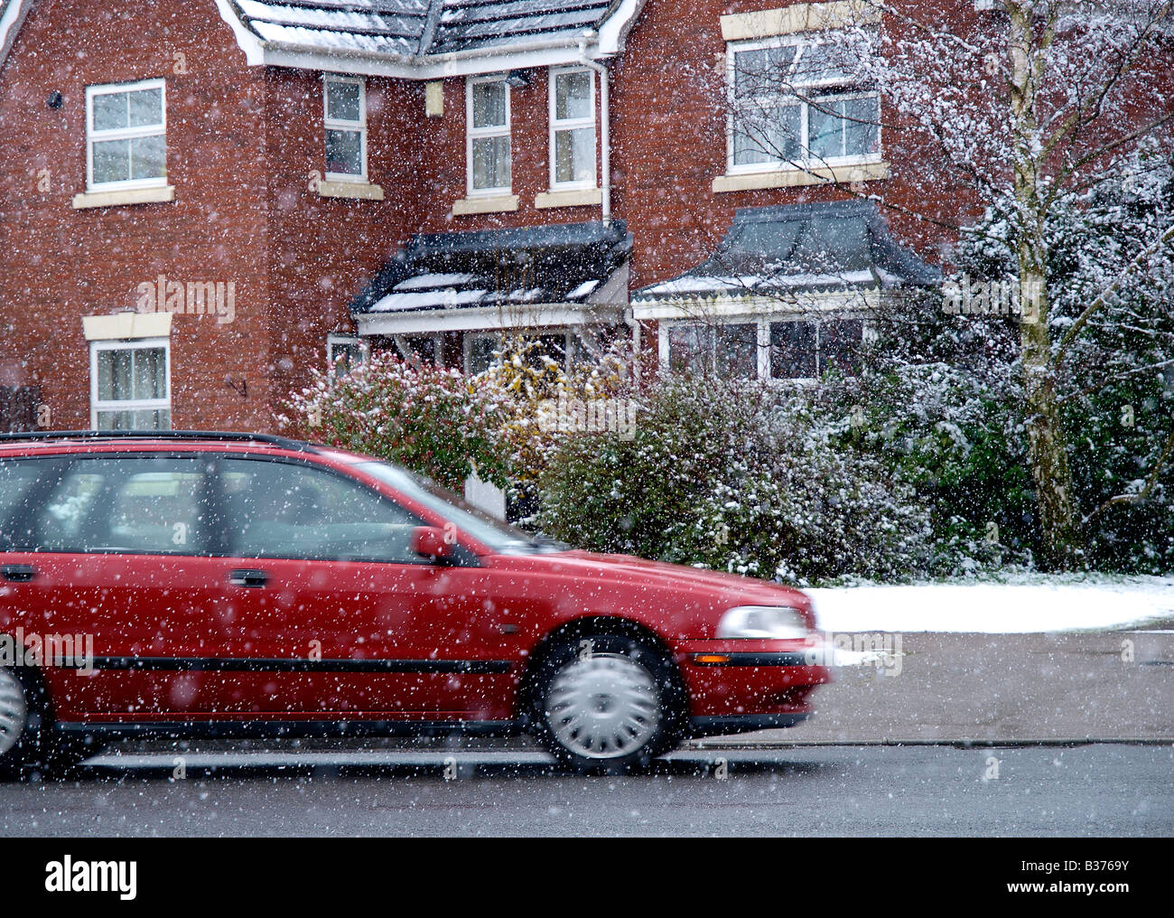 winter, snowing, red car moving along the street Stock Photo - Alamy