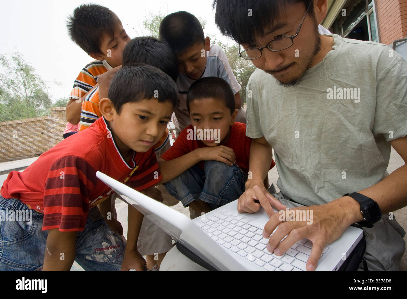 Chinese Boys Watching on as a Korean American Tourist Uses a Computer ...
