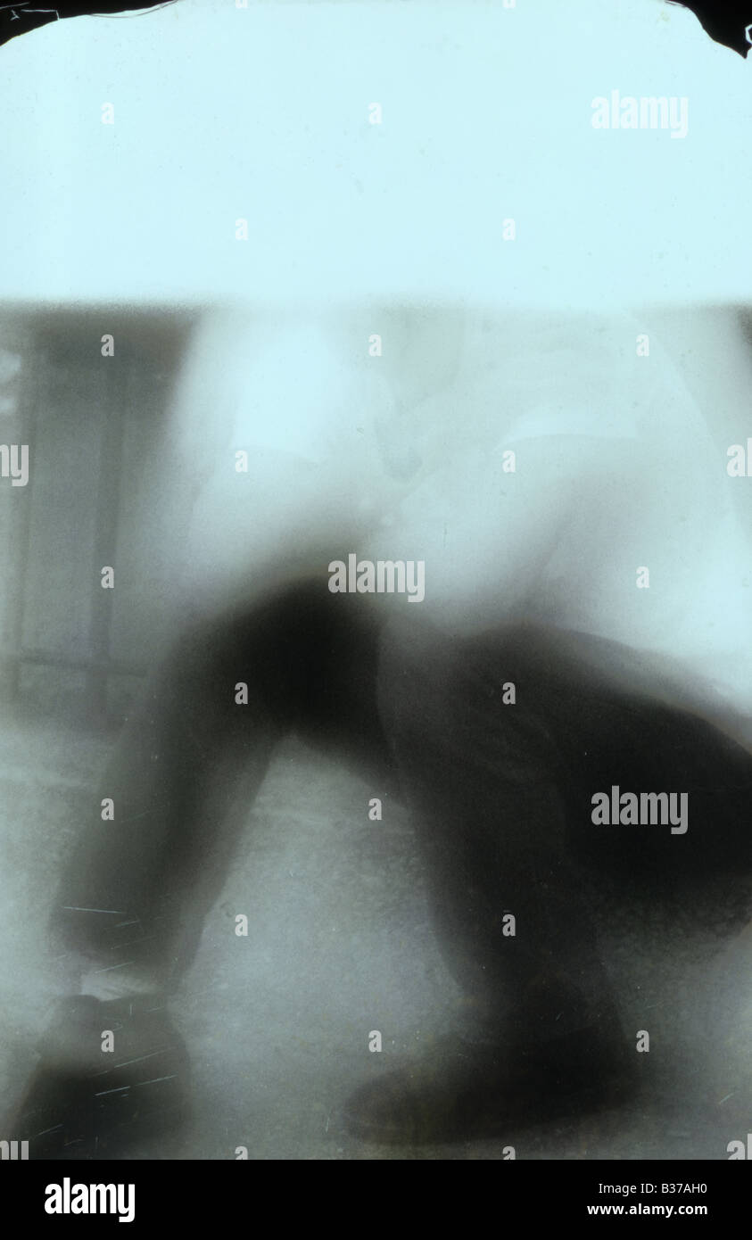 b&w of a young man sitting on a stoop; his identity and face fade off ...