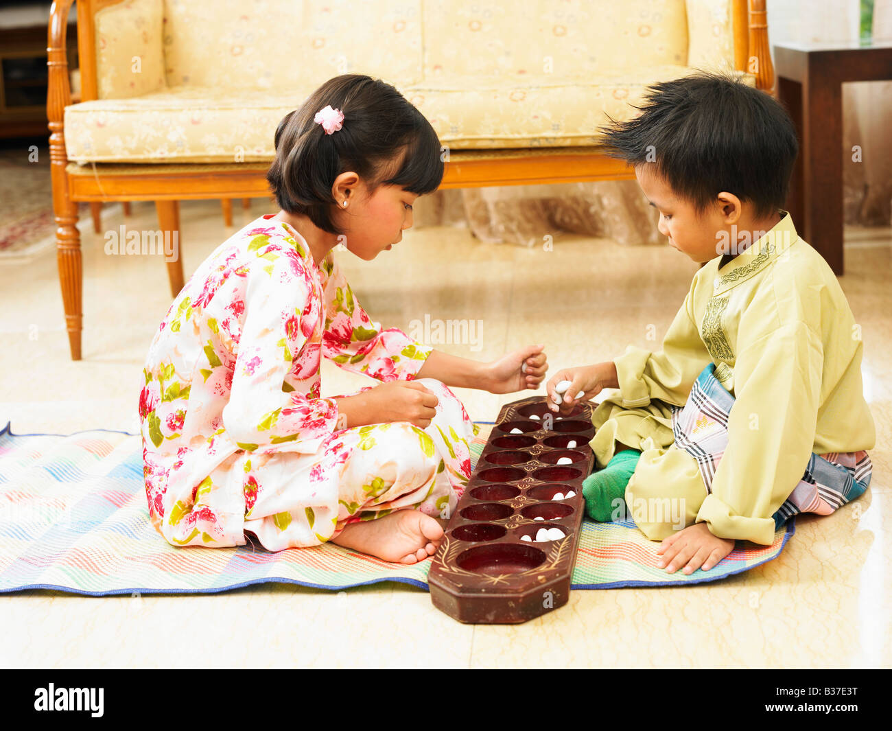 Son and daughter playing traditional congkak Stock Photo - Alamy