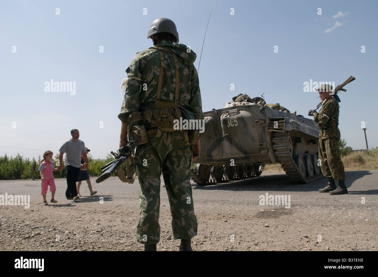 Georgian civilians walk past Russian troops as they flee the city of ...