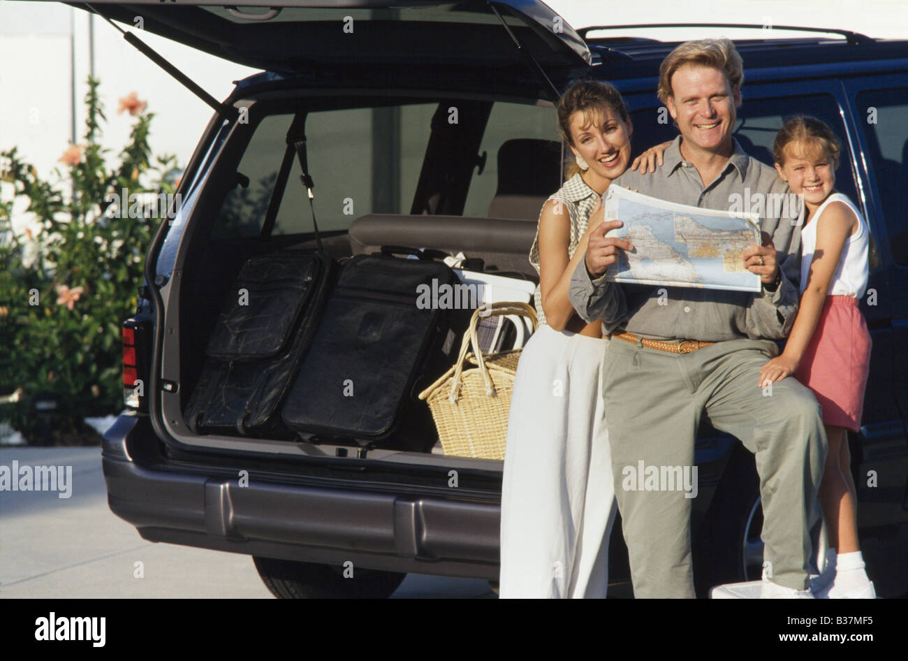Family packing minivan with luggage, checking maps, Miami Stock Photo ...