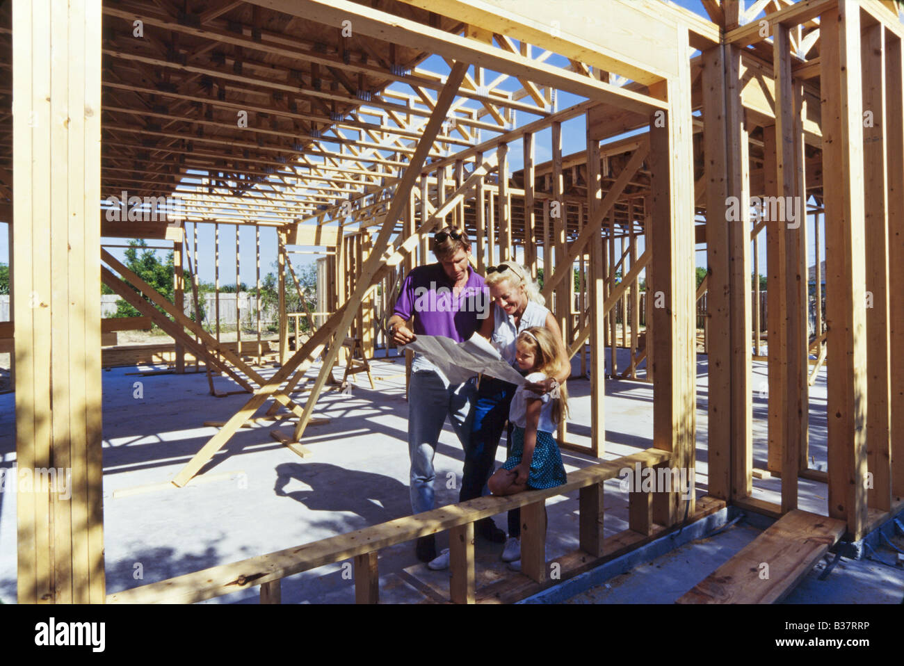 Family at home building site, looking at building plans, Miami Stock ...