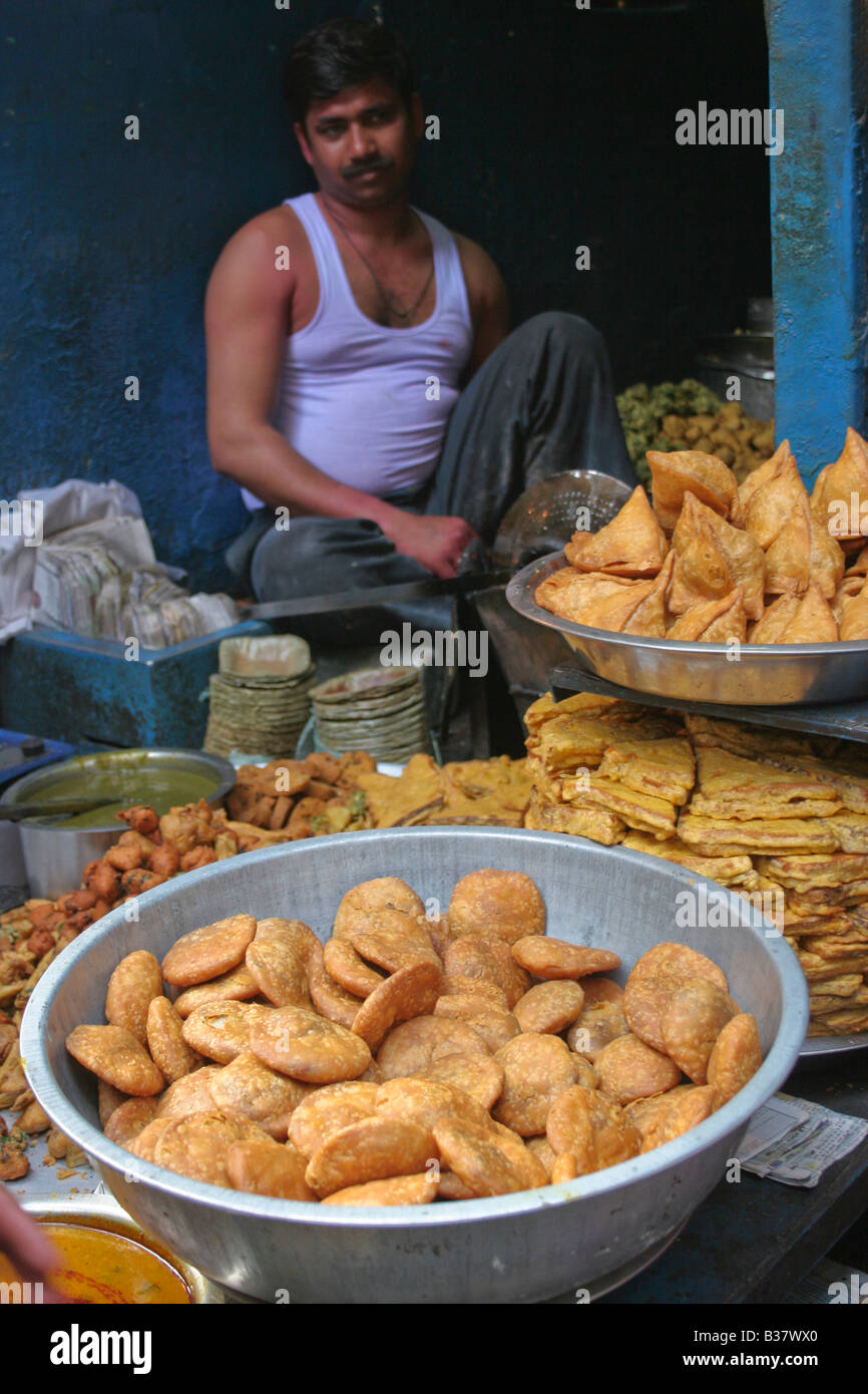 A samosa vendor sells his tasty treats in back alley near a busy Delhi ...