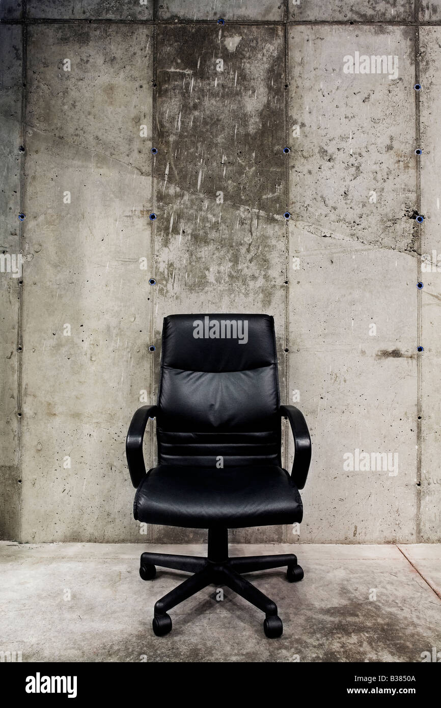 Detail of a lone leather office chair Stock Photo - Alamy