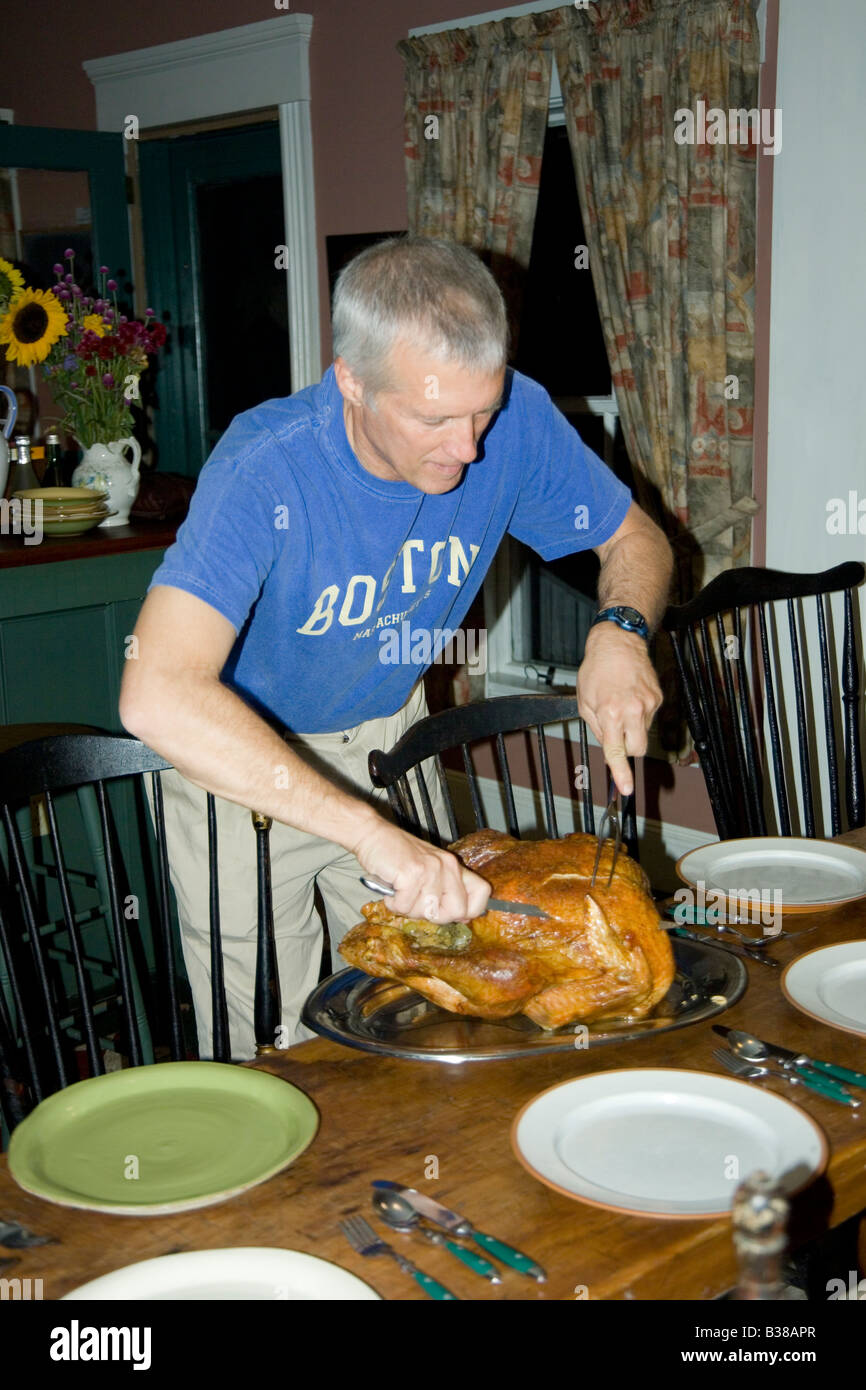 Man cutting whole roasted turkey Stock Photo - Alamy