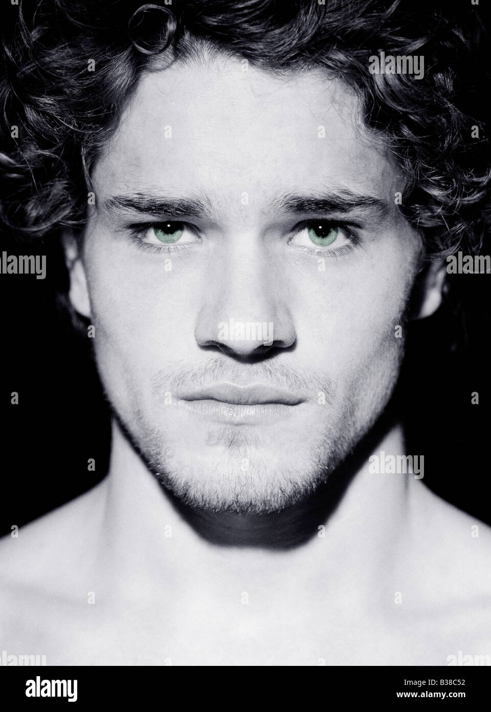 Studio portrait of young man with strong features taken in harsh light ...