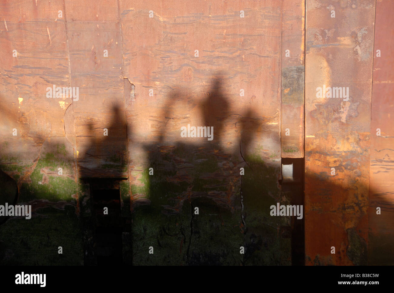 Shadows of figures silhouetted on rusty metal. UK Stock Photo - Alamy