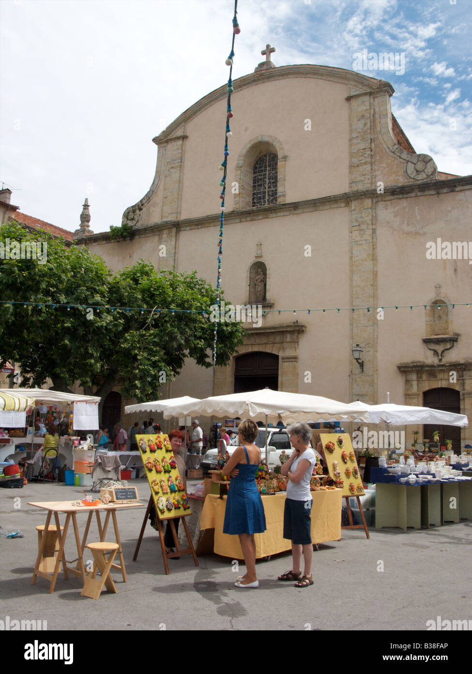Shoppers on market square in front of church in the village of Fayence ...