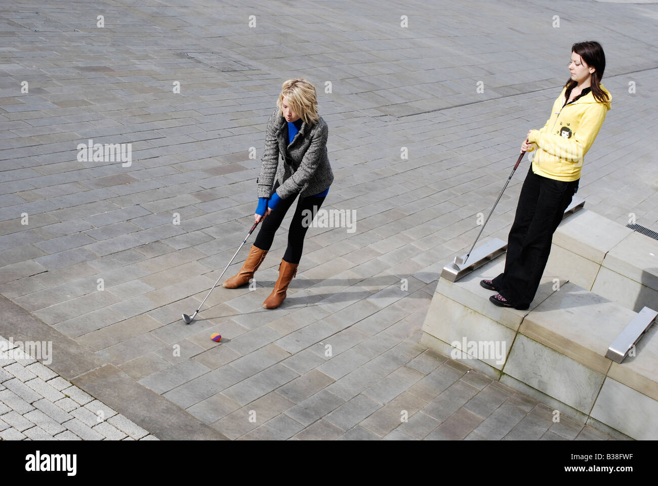 Young women playing urban golf in the city Stock Photo - Alamy
