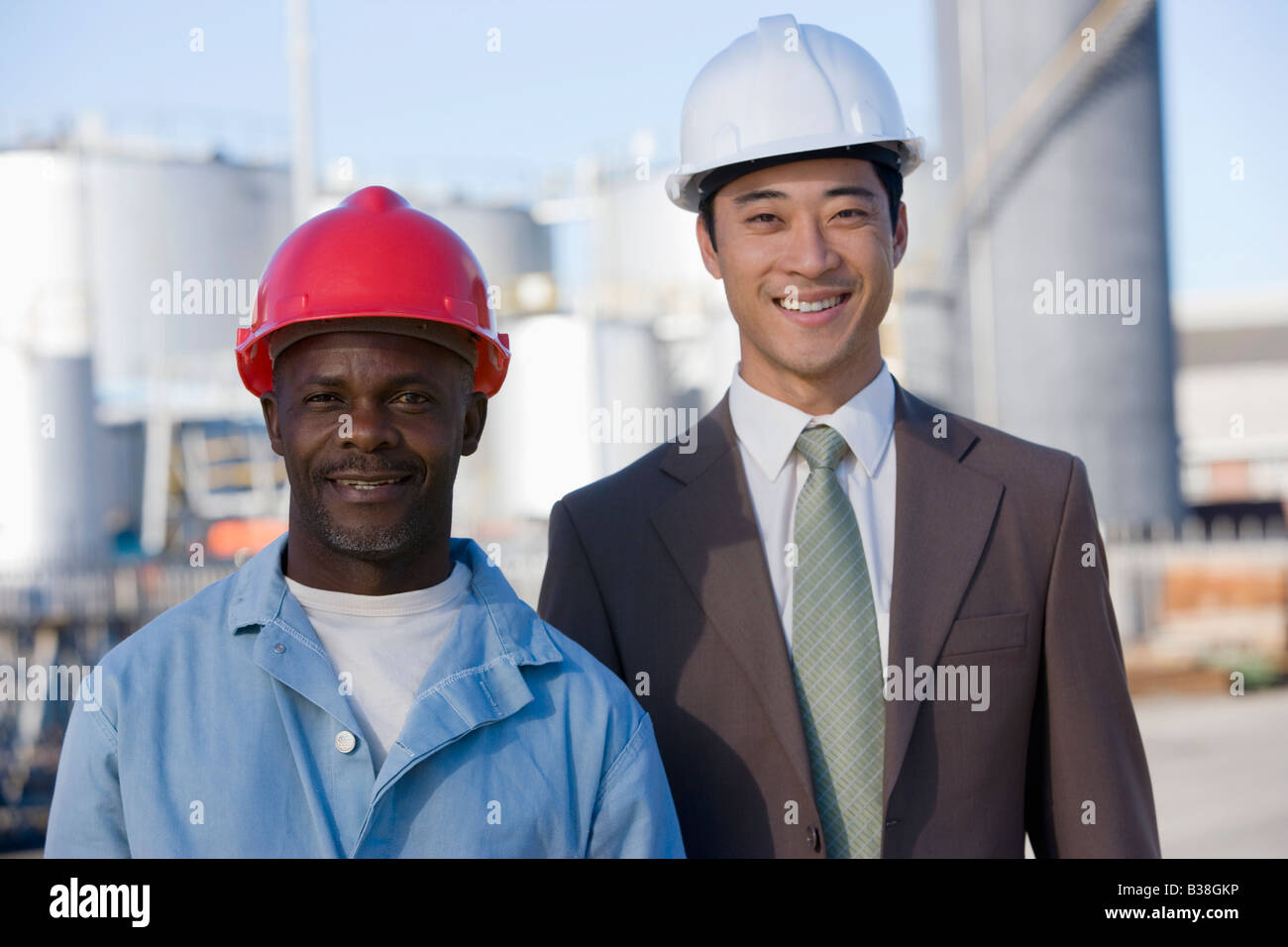 Multi-ethnic businessman and construction worker wearing hardhats Stock ...